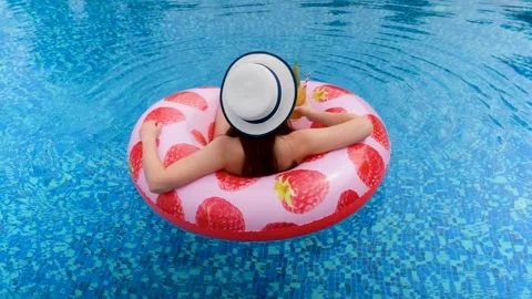 A girl in a white hat floats on an infla... | Stock Video | Pond5