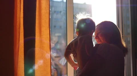 the girl at the window kissing a child i... | Stock Video | Pond5