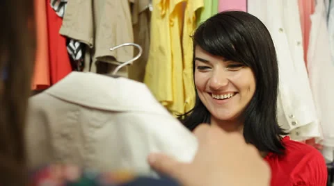 Girls run across a rack of clothes in a ... | Stock Video | Pond5