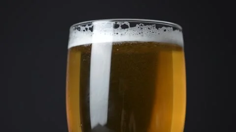 Glass of beer with fizzy bubbles and fro... | Stock Video | Pond5