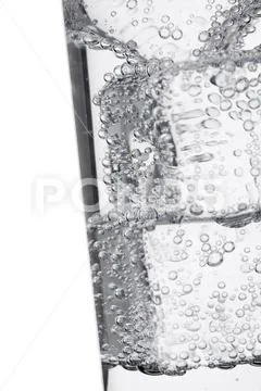 Glass of sparkling mineral water with ice cubes on white background ~ Hi Res #74013158