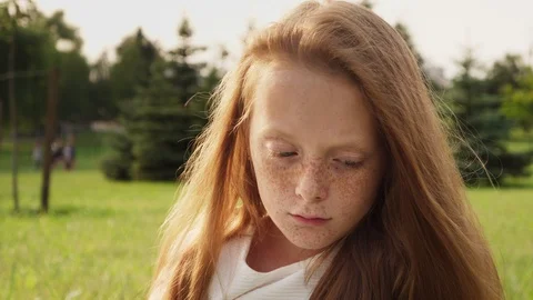 Gloomy face of sad ginger little girl wi... | Stock Video | Pond5