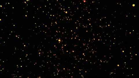 Glow particles flow in the air on black ... | Stock Video | Pond5