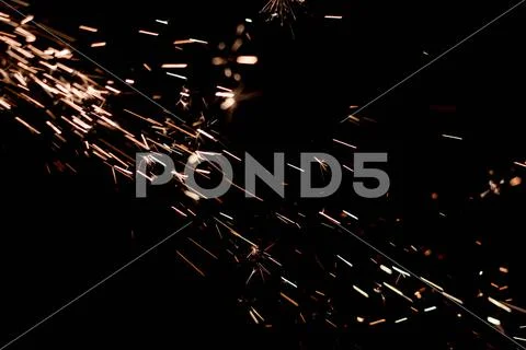 Glowing Flow of Sparks in the Dark. Fire sparks on a dark background Stock Image #144047376