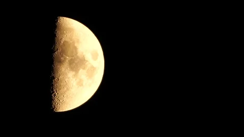 A glowing golden huge half moon seen fro... | Stock Video | Pond5