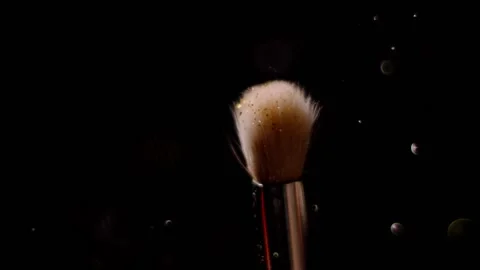 Gold glitter flying with makeup brush | Stock Video | Pond5