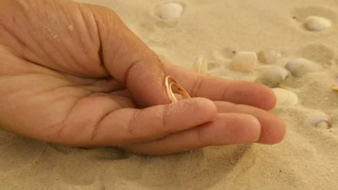 Gold wedding rings in the sea sand | Stock Video | Pond5