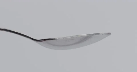 Golden Honey Falling on Spoon Over Flowi... | Stock Video | Pond5