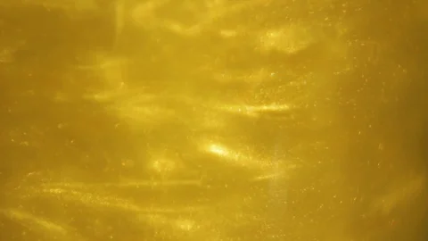 Golden ink dust floating in liquid. Gold... | Stock Video | Pond5