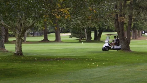 Golf carts driving around a golf course | Stock Video | Pond5
