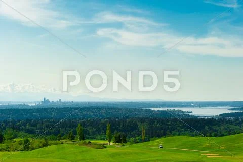 Photograph: Golf course with green grass and seattle downtown at the ...