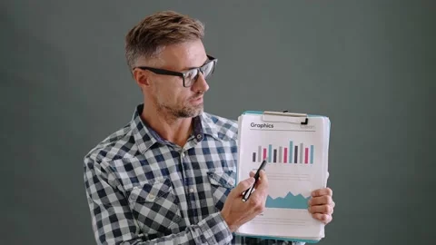 A good-looking man holding documents and... | Stock Video | Pond5