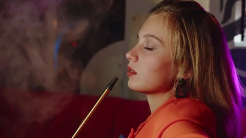 Gorgeous blonde woman smoking hookah sit... | Stock Video | Pond5