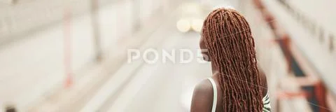 Photograph: Gorgeous woman with African braids wearing top stands on ...