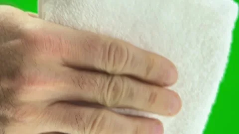 Green background man wipes the screen wi... | Stock Video | Pond5