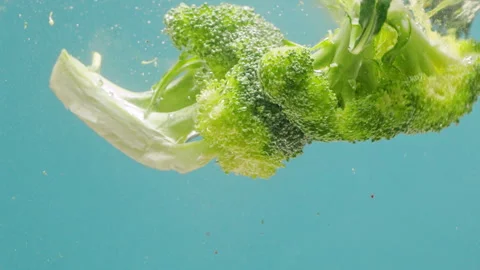 Green broccoli falling in boiling water,... | Stock Video | Pond5