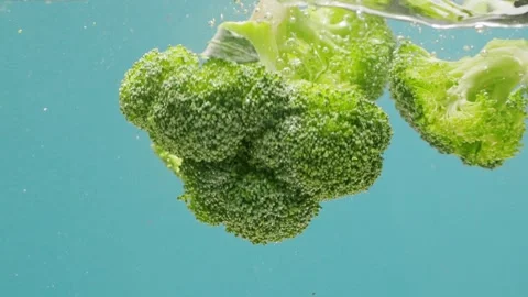 Green broccoli falling in boiling water,... | Stock Video | Pond5