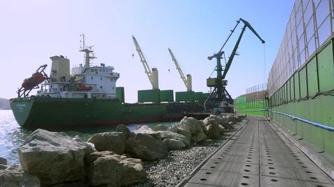 A green cargo sea vessel stands at the m... | Stock Video | Pond5