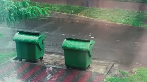 green garbage cans, heavy rain, view fro... | Stock Video | Pond5