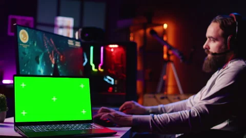 Green screen laptop next to man using ga... | Stock Video | Pond5
