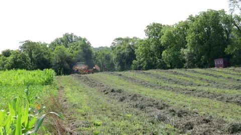 Green tractor pulling hay rake to maneu... | Stock Video | Pond5