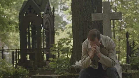 Grieving Man Sitting on Gravestone with ... | Stock Video | Pond5