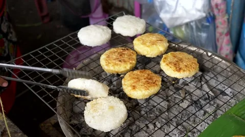 Grilled Thai Rice cakes flipped by a Tha... | Stock Video | Pond5