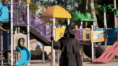 Grim Reaper Walks on Playground and Hold... | Stock Video | Pond5