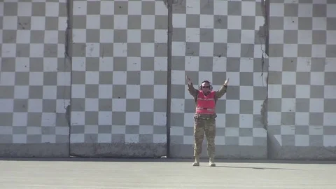 Ground marshall signalling infront of ha... | Stock Video | Pond5
