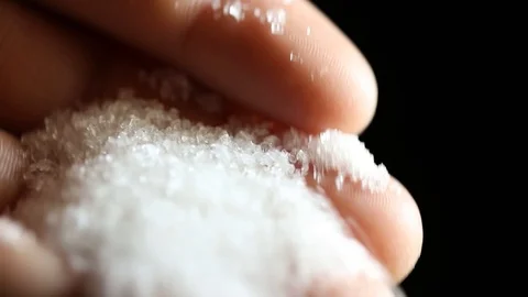 ground sugar in hand on black background | Stock Video | Pond5
