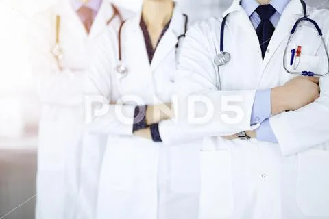 Group of modern doctors standing as a team with crossed arms and ...