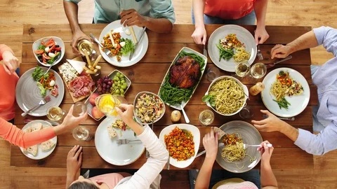 group of people eating at table with foo... | Stock Video | Pond5