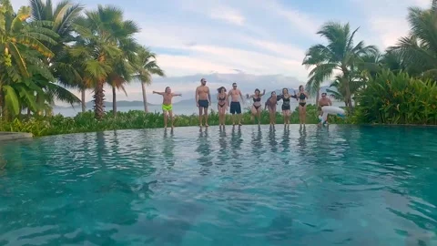 a group of people jumping into the pool | Stock Video | Pond5