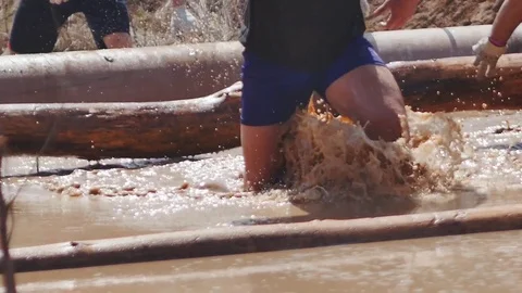 A group of people running through mud pi... | Stock Video | Pond5