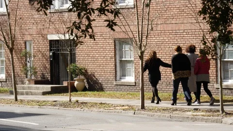 group of people walking past a brick bui... | Stock Video | Pond5