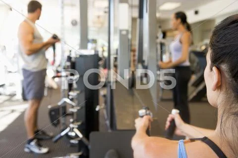 Photograph: Group of people weight training at gym #21664062