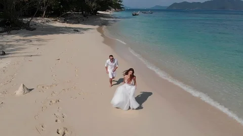 guy catches up with a girl on the beach ... | Stock Video | Pond5