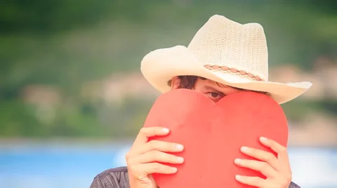 Guy in Hat Holds Red Heart in Front of F... | Stock Video | Pond5