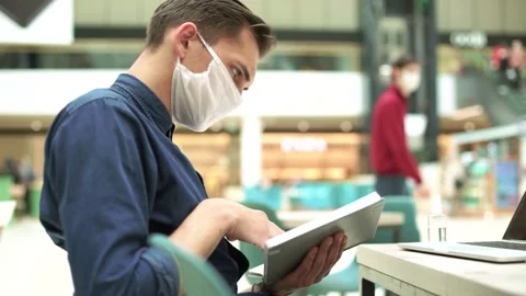 guy in a protective mask reading a book ... | Stock Video | Pond5