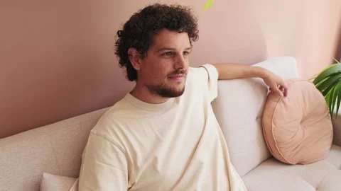 Guy relaxing sitting on the sofa in cozy... | Stock Video | Pond5