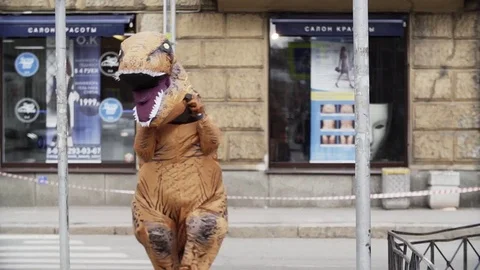 Guy in t rex costume prankster walking a... | Stock Video | Pond5