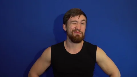 The guy winks, standing on blue backgrou... | Stock Video | Pond5