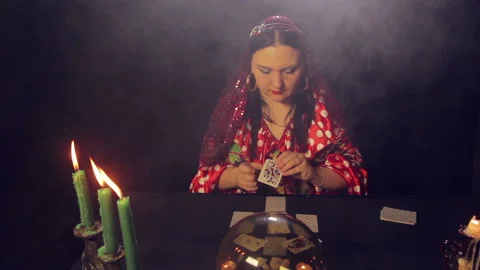 A gypsy fortune teller at the table by c... | Stock Video | Pond5