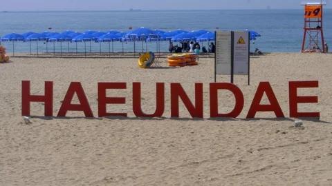 Haeundae sign on the beach with ocean ba... | Stock Video | Pond5