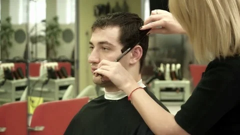 Hairdresser is making a haircut for a ma... | Stock Video | Pond5