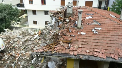 A half destroyed house and an excavator.... | Stock Video | Pond5