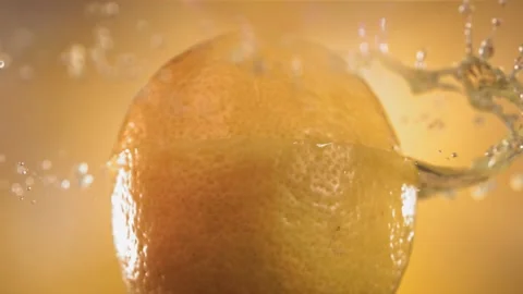 Half Lemon falling and splashing on yell... | Stock Video | Pond5