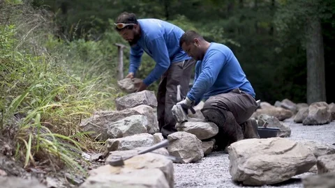 Hammering at a rock to make it fit bette... | Stock Video | Pond5