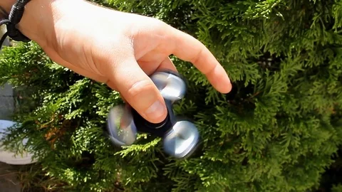 Hand with black steel rolling spinner. G... | Stock Video | Pond5