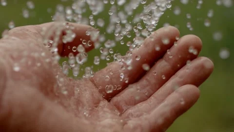 Hand catching rain drops on blurred gree... | Stock Video | Pond5